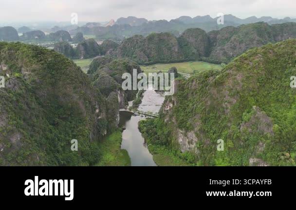 Beautiful aerial footage of Tam Coc river flowing between limestone ...