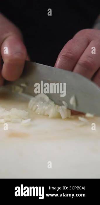 Vertical video. Kitchen cutting. Spicy ingredient. Hands mincing white ...