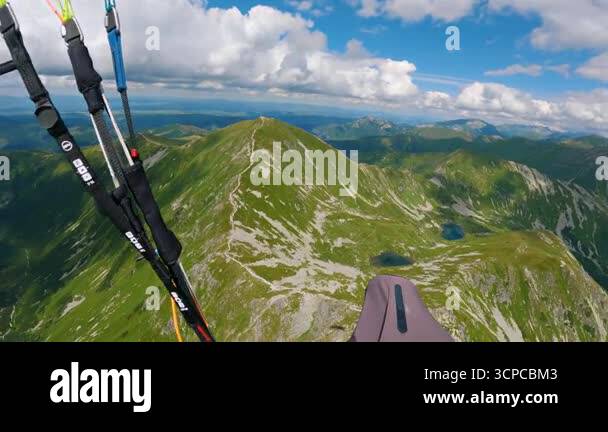 Exciting POV paragliding flight above green mountain peaks. Extreme ...
