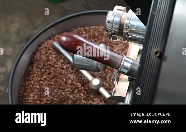 Coffee roaster machine at coffee roasting process. Mixing coffee beans ...