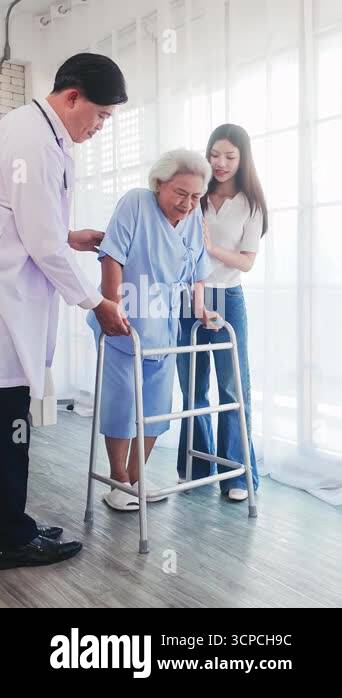 Elderly patient using a walker with support from a doctor and caregiver ...