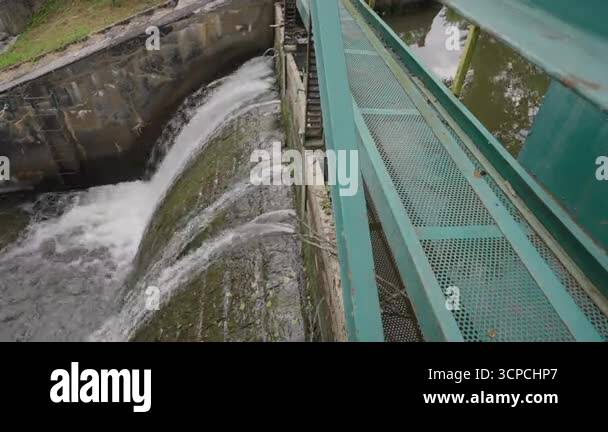 Powerful water streams cascade down a concrete spillway at a small ...