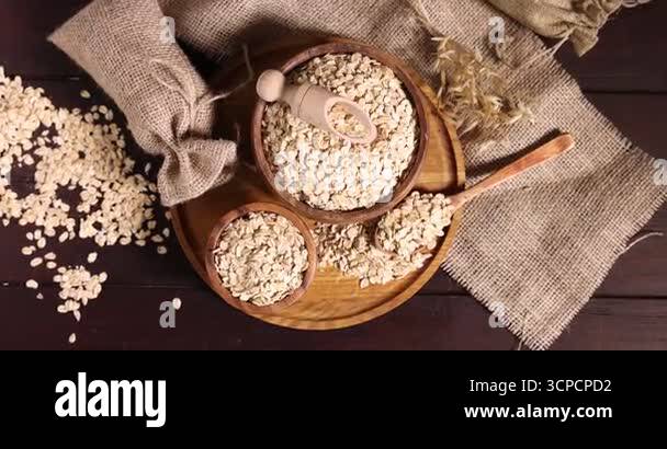 Oat grains and florets on wooden table, flat lay. Camera moving in ...