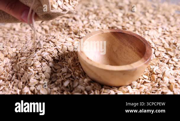 Woman pouring oat flakes into bowl at table, closeup Stock Video ...