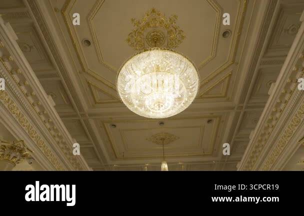 Ceiling decorated with geometric patterns frames massive chandelier ...