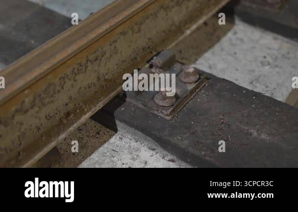 Steel connections on rails glisten strongly while surrounding space ...