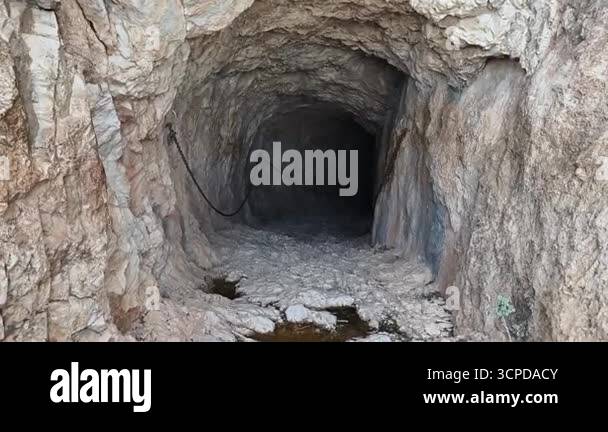 Exploring a rugged and mysterious tunnel characterized by rocky walls ...