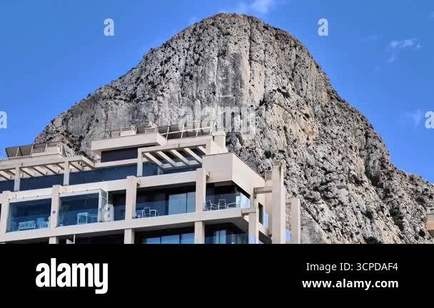 A breathtaking view of a rocky mountain towering over a sleek modern ...