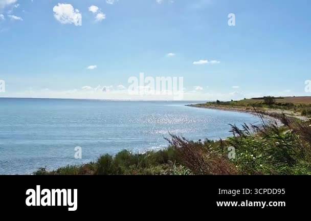 A breathtaking and serene coastal landscape featuring gentle waves, a ...