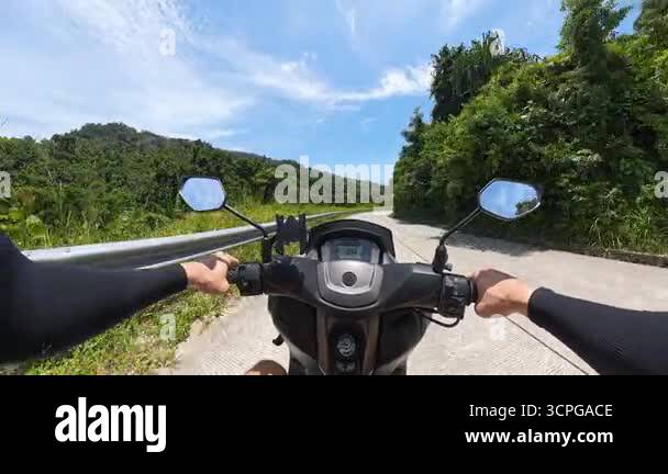 Scooter Rider Driving on Concrete Road Through Green Hills Under Blue ...
