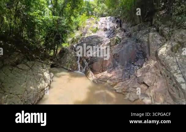 View of natural waterfall and jungle rocks with water flowing between ...
