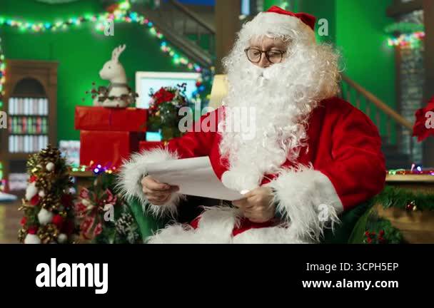 Elderly man dressed as Santa Claus opening letter received from kids ...