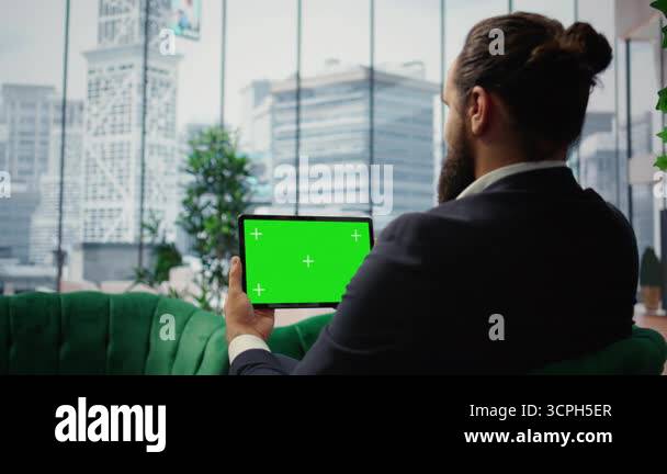 Corporate male entrepreneur in office with chroma key screen, reviewing ...