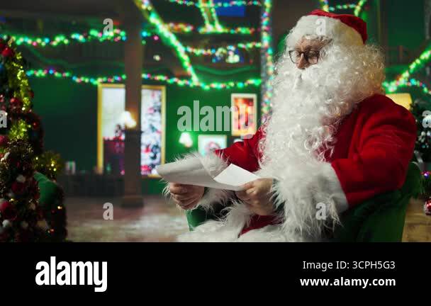 Senescent man playing Santa Claus role opening letter received from ...