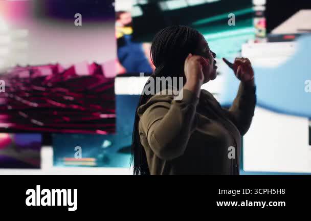 Woman in front of digital videowall amazed by streaming videos and ...