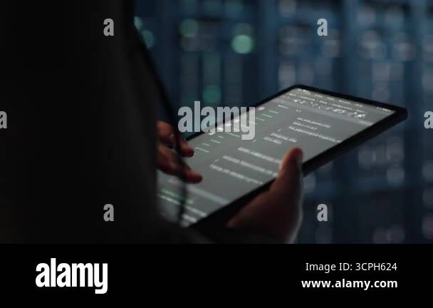 Close up of programmer in data center using tablet to implement ...