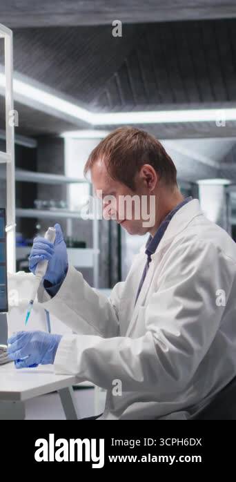 Vertical Video Male scientist handles pipette with droplet over jar ...