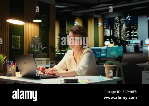 Business employee leaning on her desk showing symptoms of burnout ...