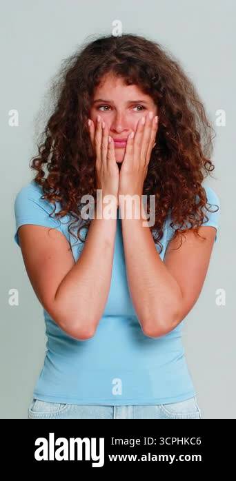Young woman covering face with hands experiencing embarrassment, shy ...