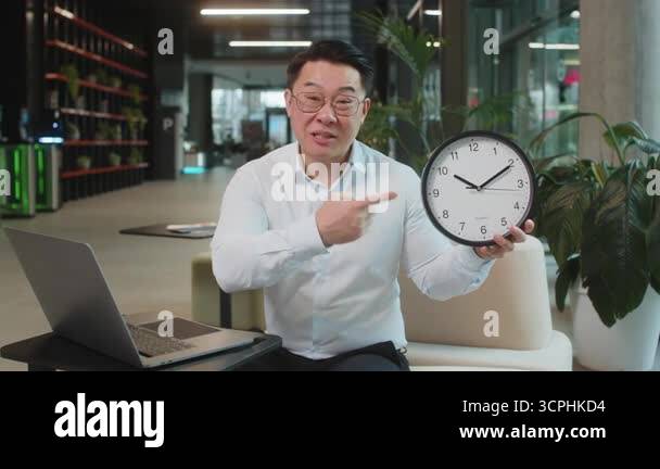 It is your time. Mature boss businessman with laptop showing time on ...