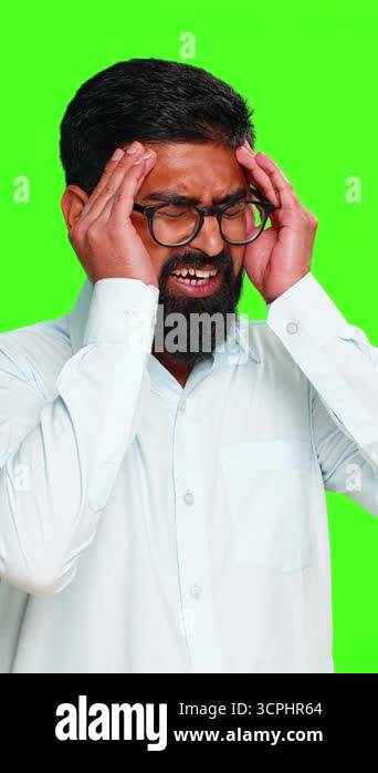 Indian man presses fingers to temples with tense face, simulating ...