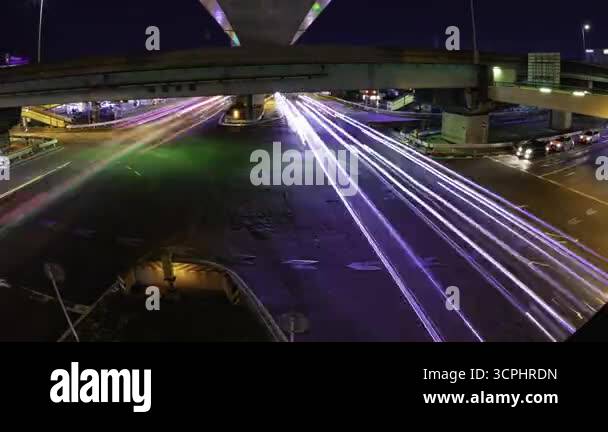 A night timelapse of traffic jam under the city overpass in ...