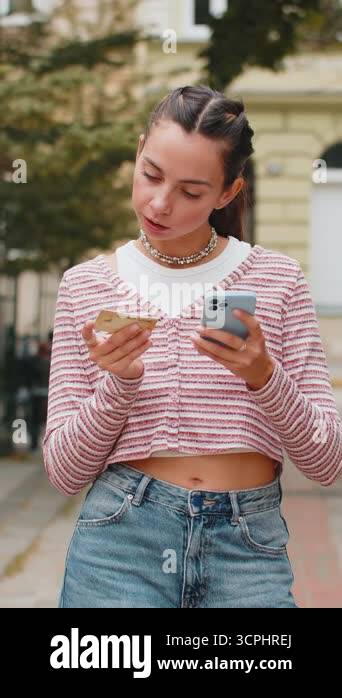 Caucasian young woman using credit bank card smartphone while ...