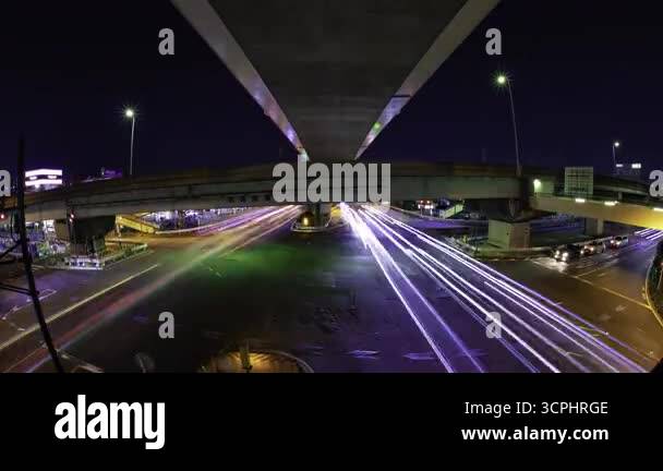 A night timelapse of traffic jam under the city overpass in ...