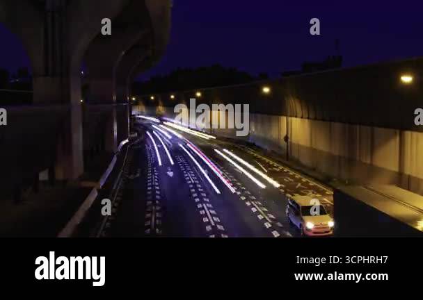 A night timelapse of traffic jam under the city overpass in ...
