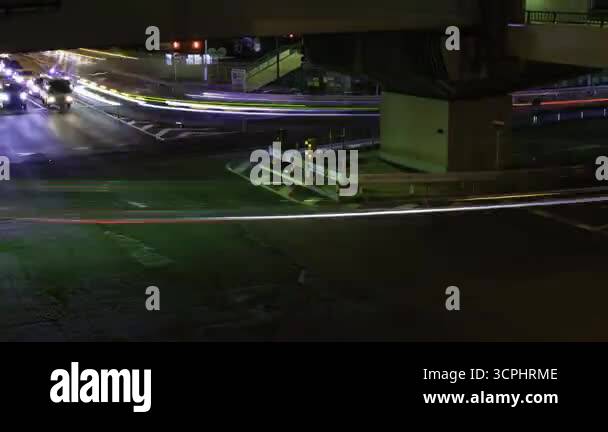 A night timelapse of traffic jam under the city overpass in ...