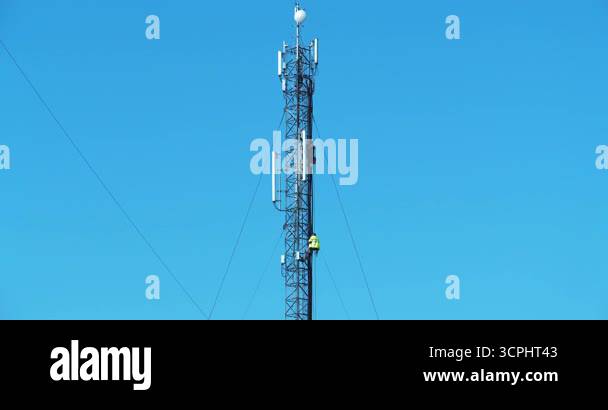 Cell tower on blue background. Maintenance staff at work. High-altitude ...