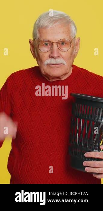 Senior old man taking off throwing out glasses into bin after medical ...
