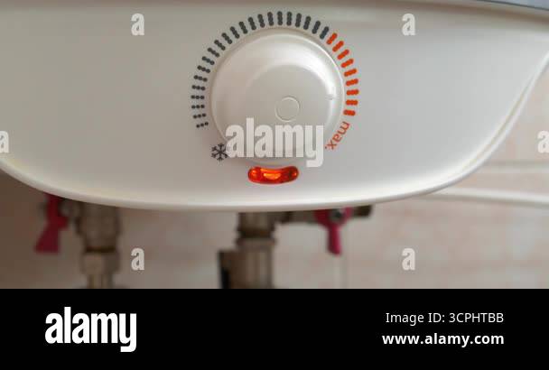 Boiler with temperature regulator for heating cold water. Red light ...