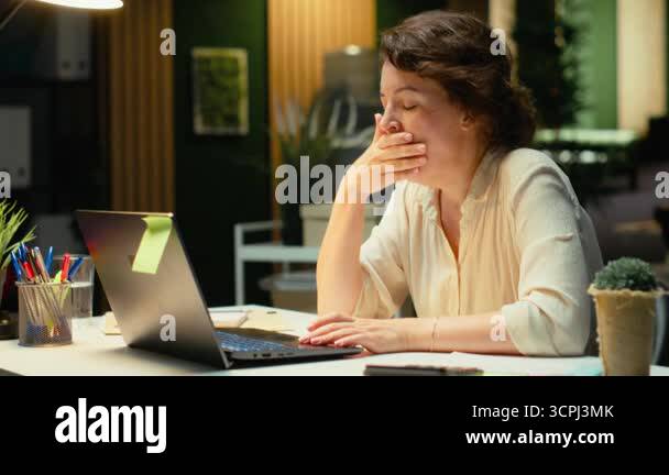 Restless sleepy businesswoman yawning in the office struggling to stay awake, dealing with sleep ...