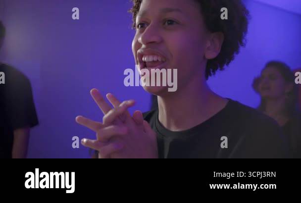 Teenage boy smiling and singing during evangelical church worship while ...