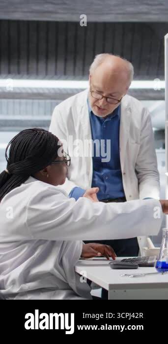 Vertical Video Diverse researchers in lab workspace conducting ...