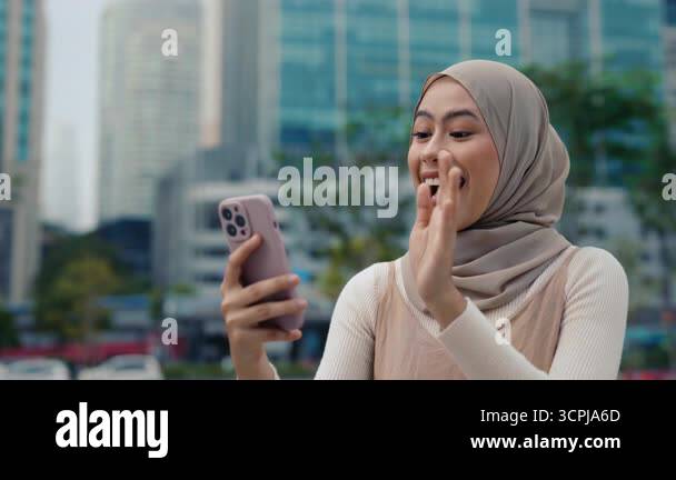Portrait of happy Muslim woman uses video chat on smartphone stands ...