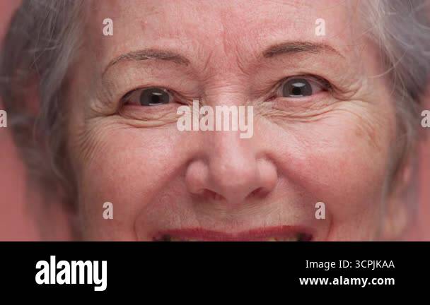 Macro portrait of a senior woman joyful face, showing bright eyes ...