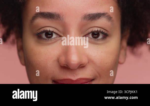 Extreme close-up of a young woman face showing raised eyebrows and a ...