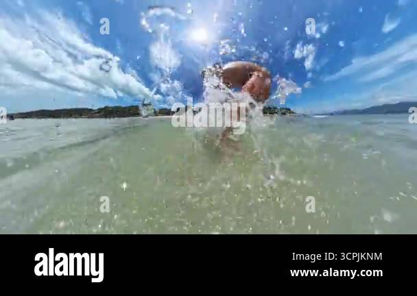 Man Charging Into Sea With Water Droplets Flying in Slow Motion and Low ...