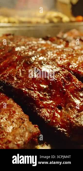 Vertical video. Close up of grilled barbecue ribs with shiny glaze ...
