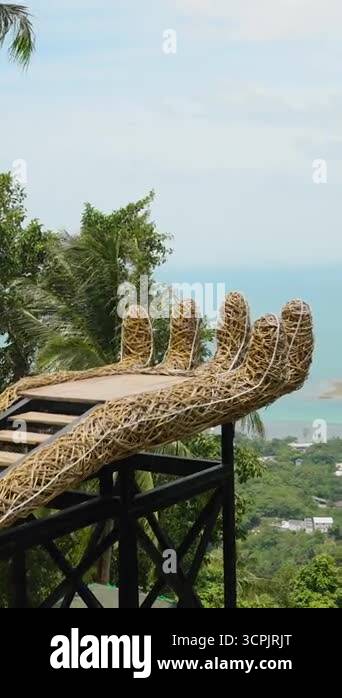 Vertical video. Giant Hand Shaped Structure Rising Among Palm Trees ...