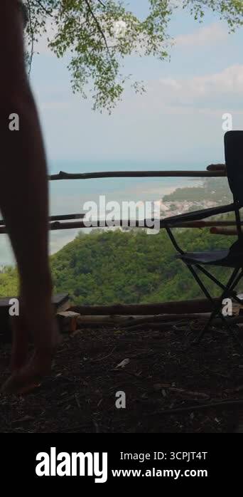 Vertical video. Woman Walking Toward Black Folding Chair on Wooden ...