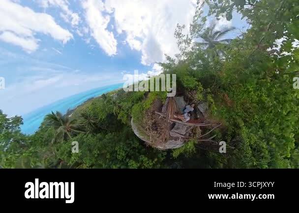 Man and Woman Sitting on Wooden Lookout Above Jungle Overlooking Ocean ...