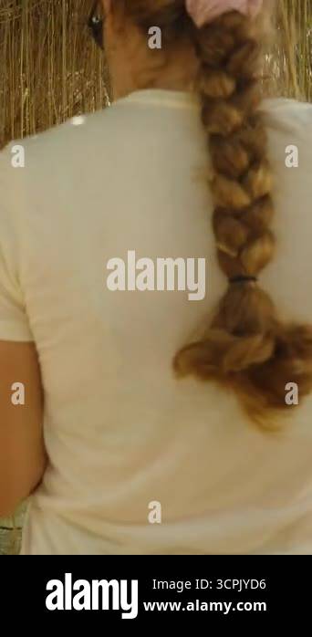 Vertical video. Woman with Long Braided Hair Walking Through Hanging Roots in Bright Tropical ...