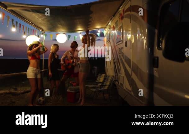 young group of people having fun in nature on camping dancing singing ...
