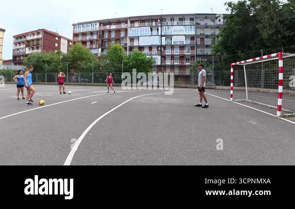Urban soccer field hosts a penalty kick sequence with female athletes ...