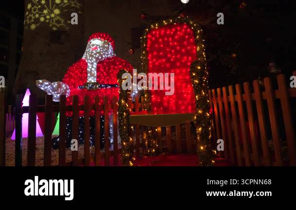 Luminous santa claus sitting on his illuminated throne, greeting during ...