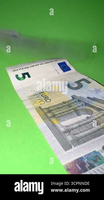 Euro banknotes in denominations of five, twenty, and fifty euros slowly ...