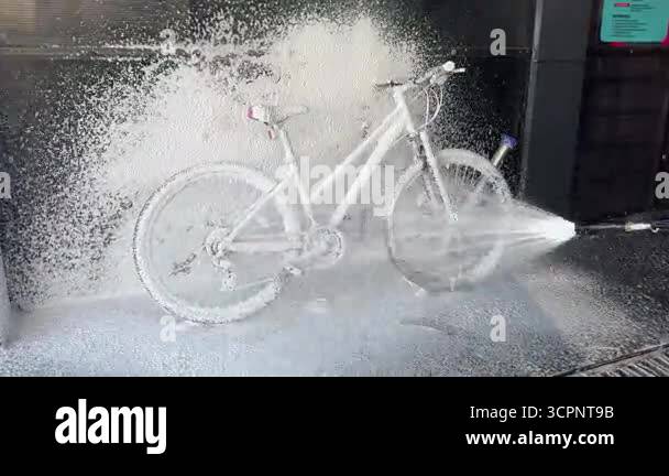 Washing a bicycle with foam at a self-service car wash. Bike care Stock ...